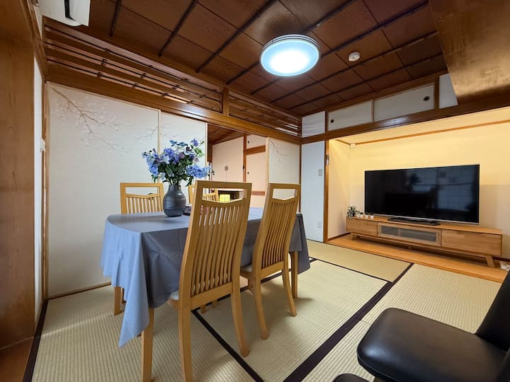 畳と布団でくつろぐ純和風のお部屋、広いバルコニー付き、テーブルと椅子があり。 - Roppongi